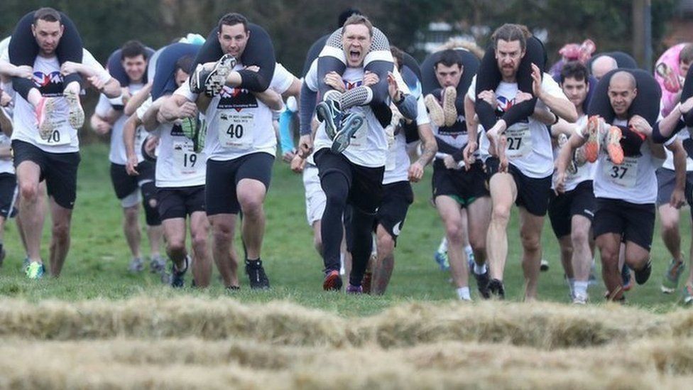 Wife carrying race: Winners in proposal joy on finish line - BBC News
