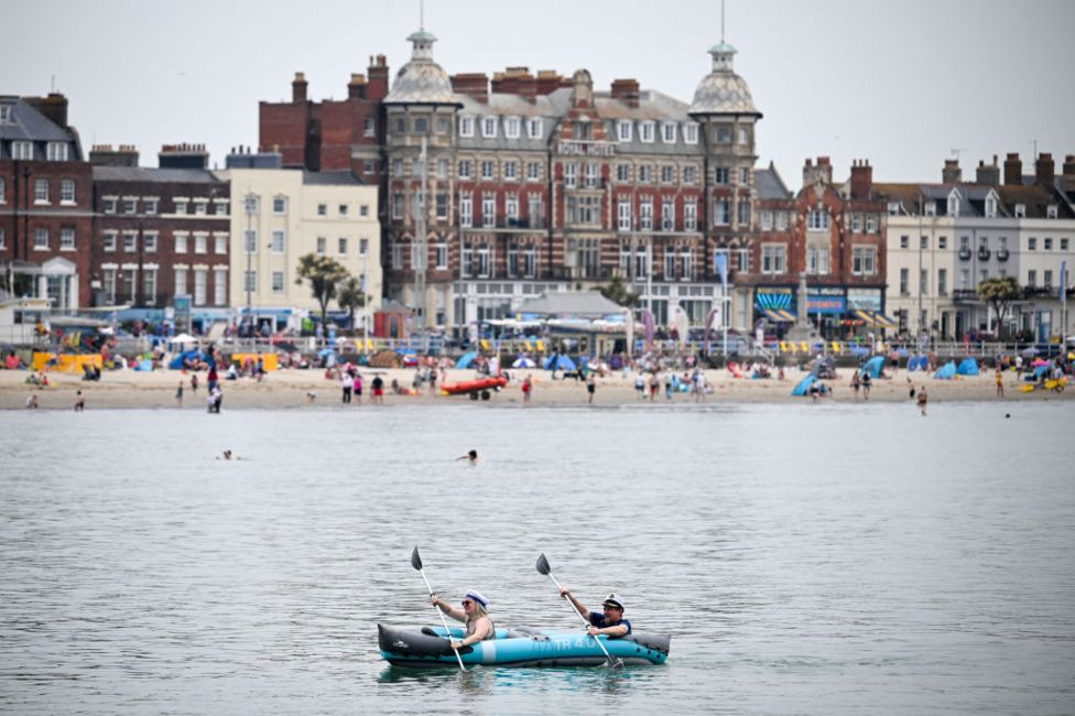 In pictures: Visitors flock to seaweed strewn Weymouth Beach - BBC News