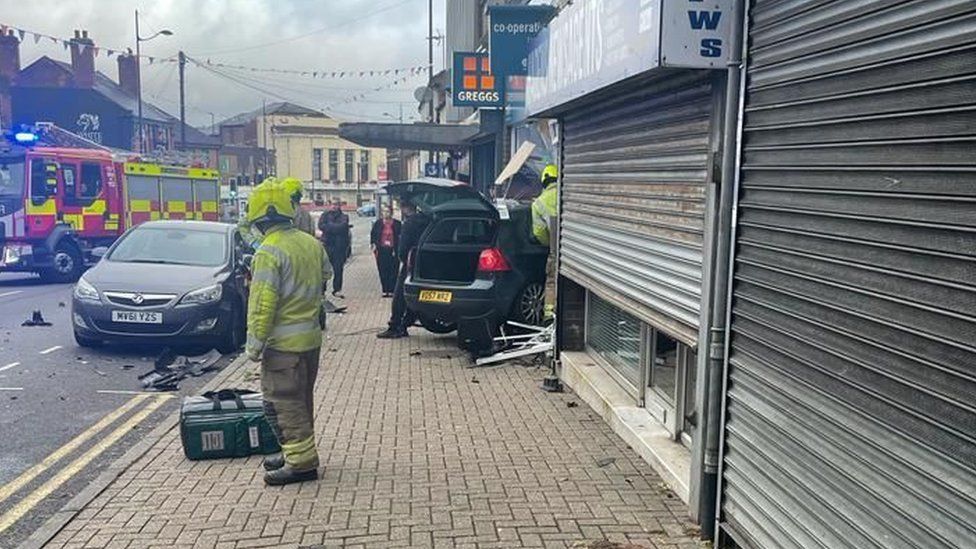 Two arrested after car crashes into Sedgley shop front - BBC News