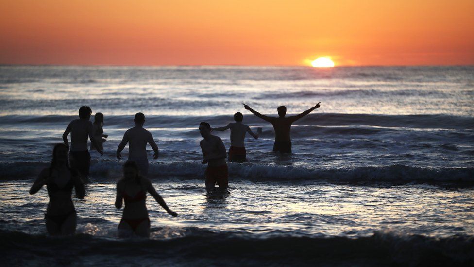 In pictures: Students dive in for May Day Dip - BBC News