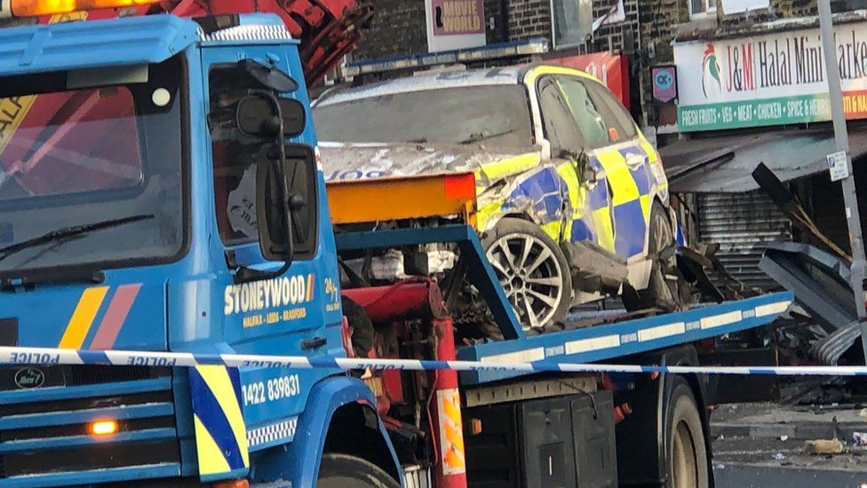 Bradford police car crash causes damage to row of buildings - BBC News
