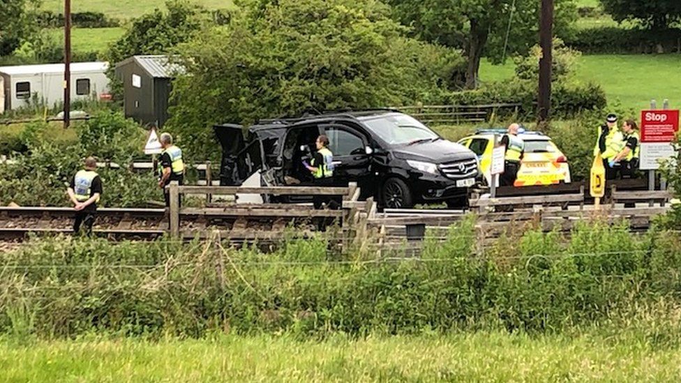 Person seriously injured as train hits van at level crossing - BBC News