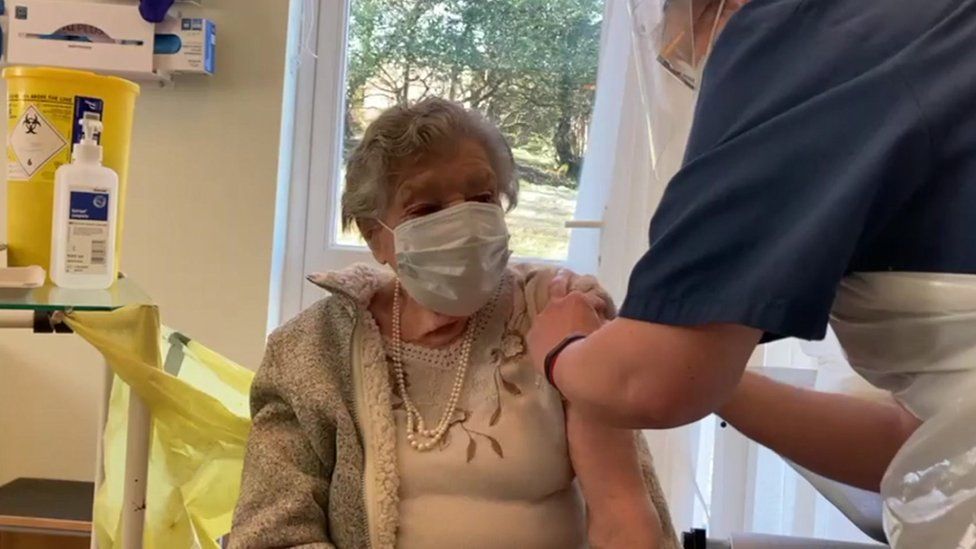 Devon woman marks 100th birthday with Covid-19 jab - BBC News