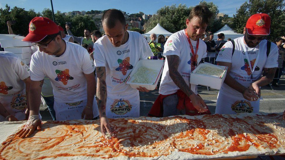 Pictures: Guinness World record set for longest pizza ever - BBC Newsround