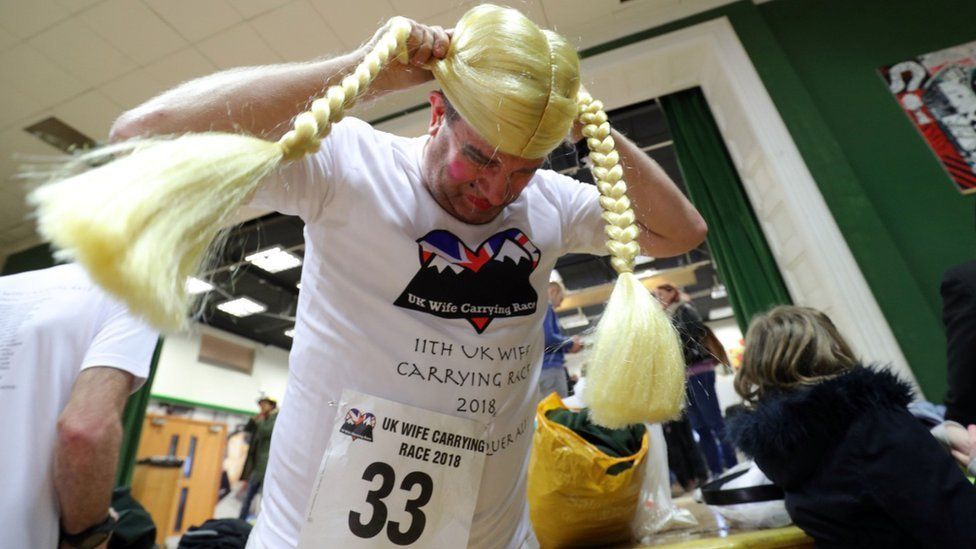 UK wife-carrying contest takes place in Dorking - BBC News