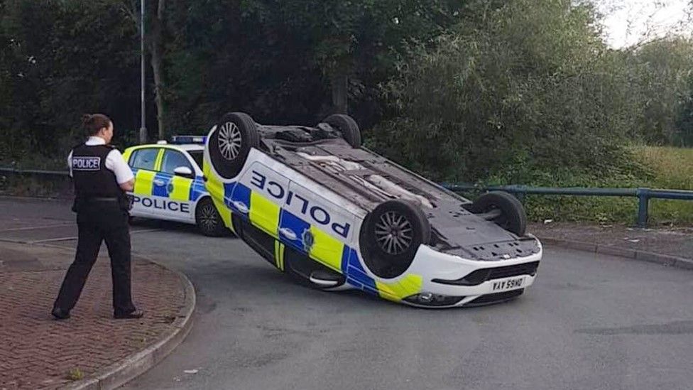 Gang of men flips police car on its roof in Kirkby - BBC News