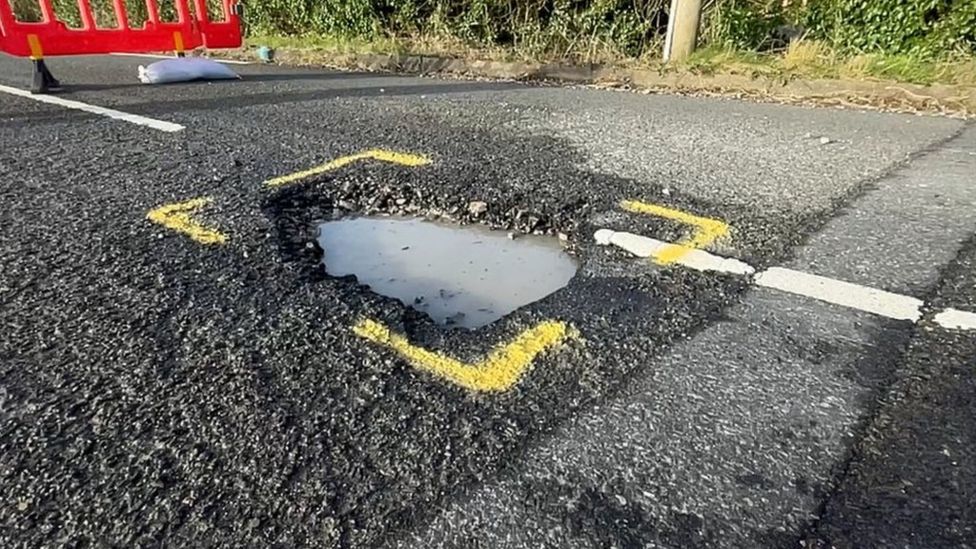 Wrenbury sign warns potholes could 'break your soul' - BBC News