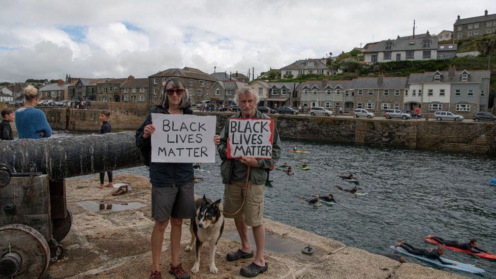 Cornwall surfers paddle out for anti-racism protest - BBC News