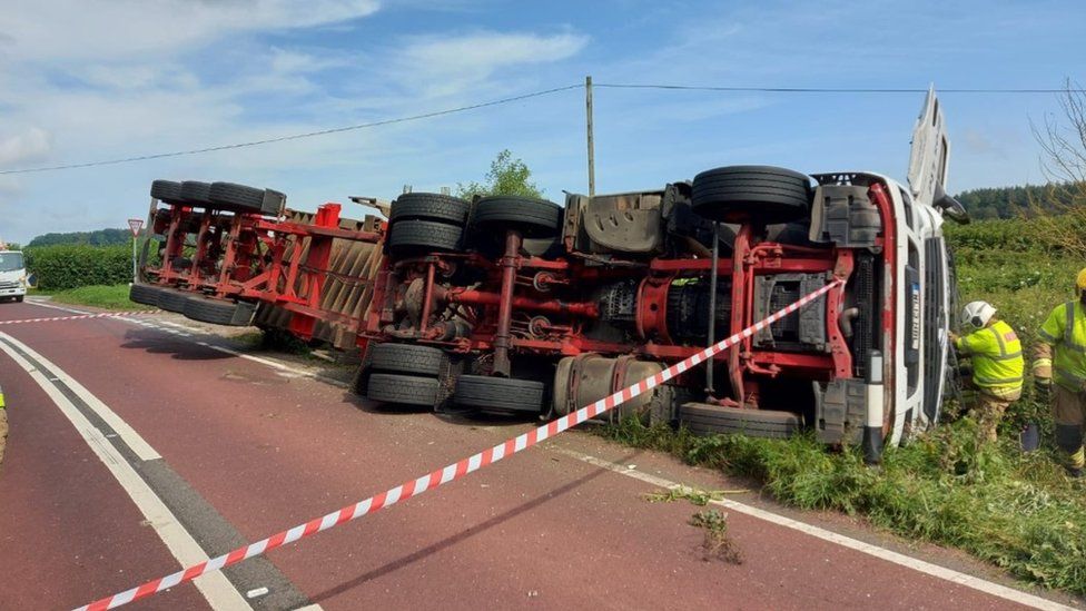Dorset overturned lorry shuts road after shedding load - BBC News