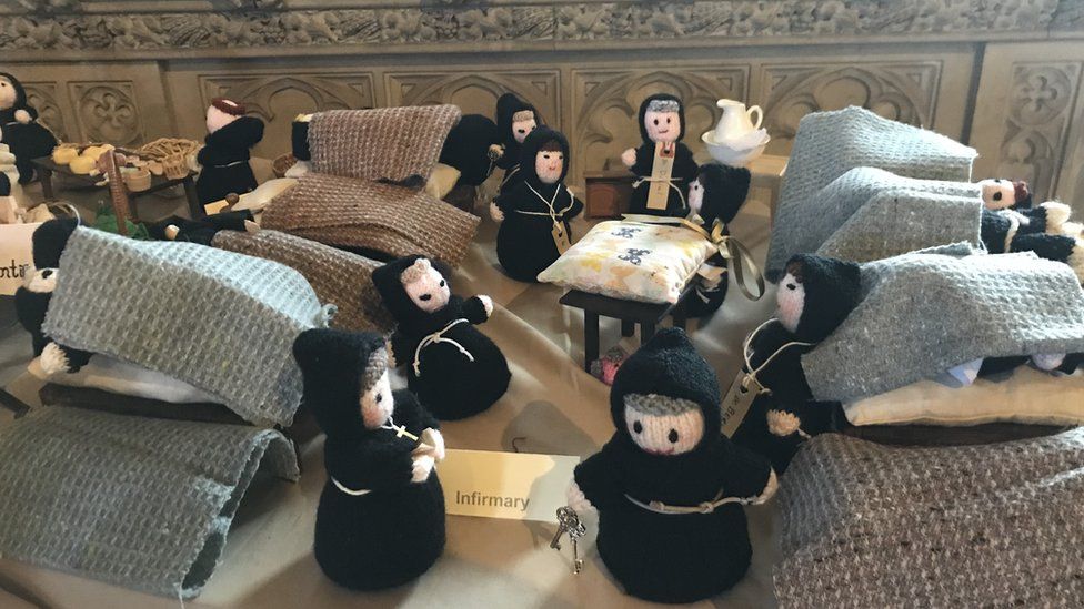 Knitted monks go on show in Tewkesbury Abbey - BBC News
