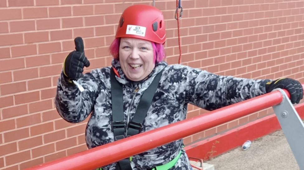 Crewe woman with spinal condition abseils down Anfield Stadium - BBC News