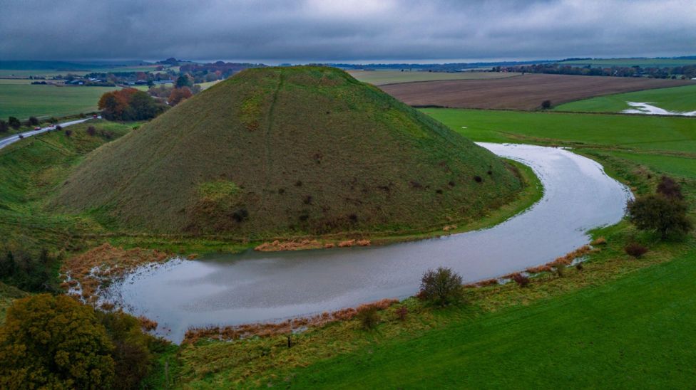 Moat forms around ancient Silbury Hill monument after heavy rain - BBC
