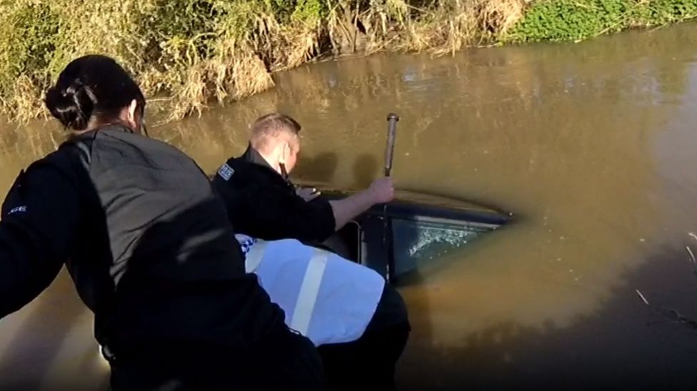Woman dragged to safety from sinking car - BBC News