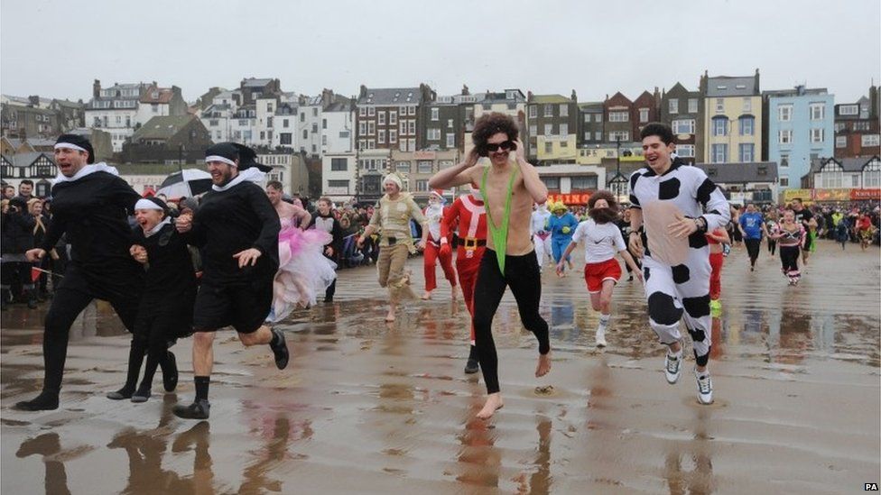 Swimming and singing: New Year in pictures - BBC News