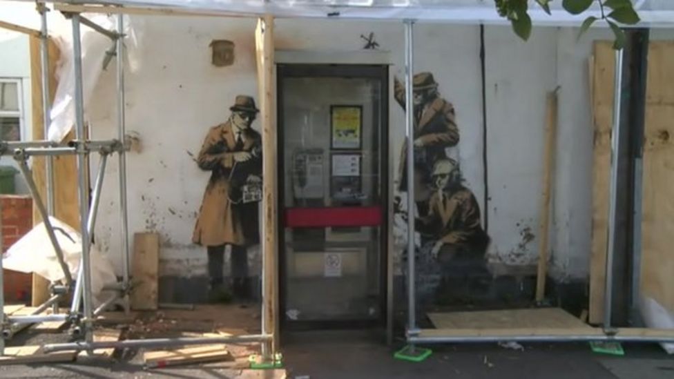 Banksy 'Spy Booth' hoardings removed in Cheltenham - BBC News