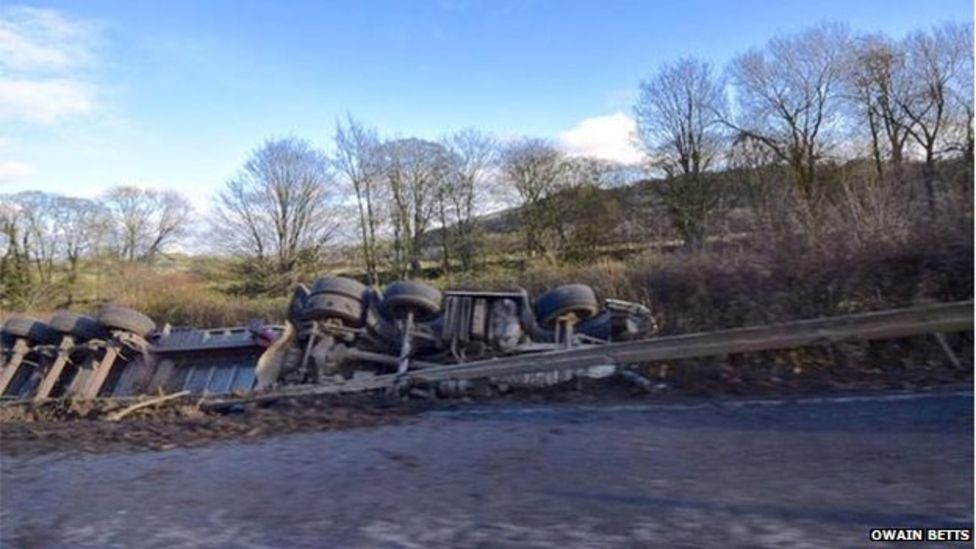 Spilled feed lorry still in canal in Abermule, Powys - BBC News